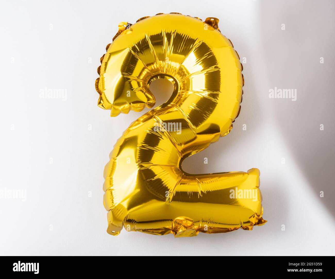 Number 2 golden balloon party decor on white background, birthday ...