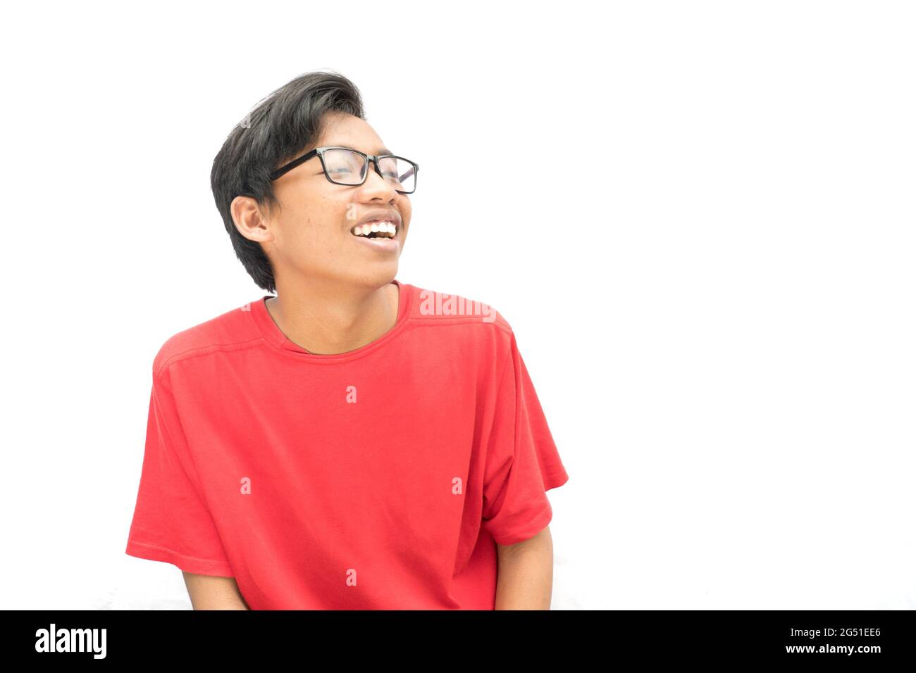 Happy smiling Indonesian guy wearing a red t-shirt and eyeglasses ...