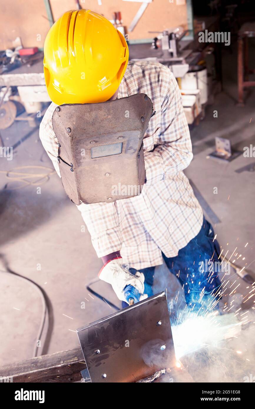 young worker while welding in a steel mill Stock Photo - Alamy