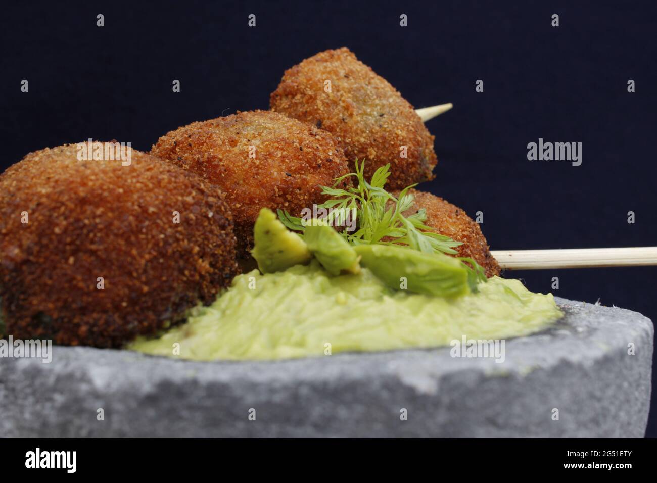 Breaded tomato brochettes in molcajete with guacamole, Mexican dish ...