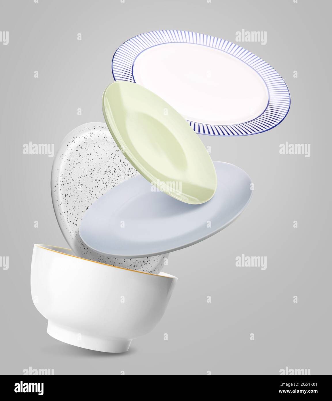 Flying clean plates on grey background Stock Photo - Alamy