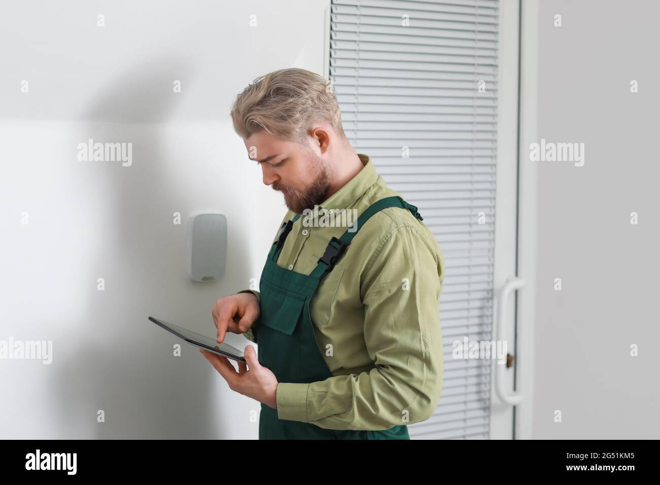 Worker with tablet computer checking alarm system indoors Stock Photo ...