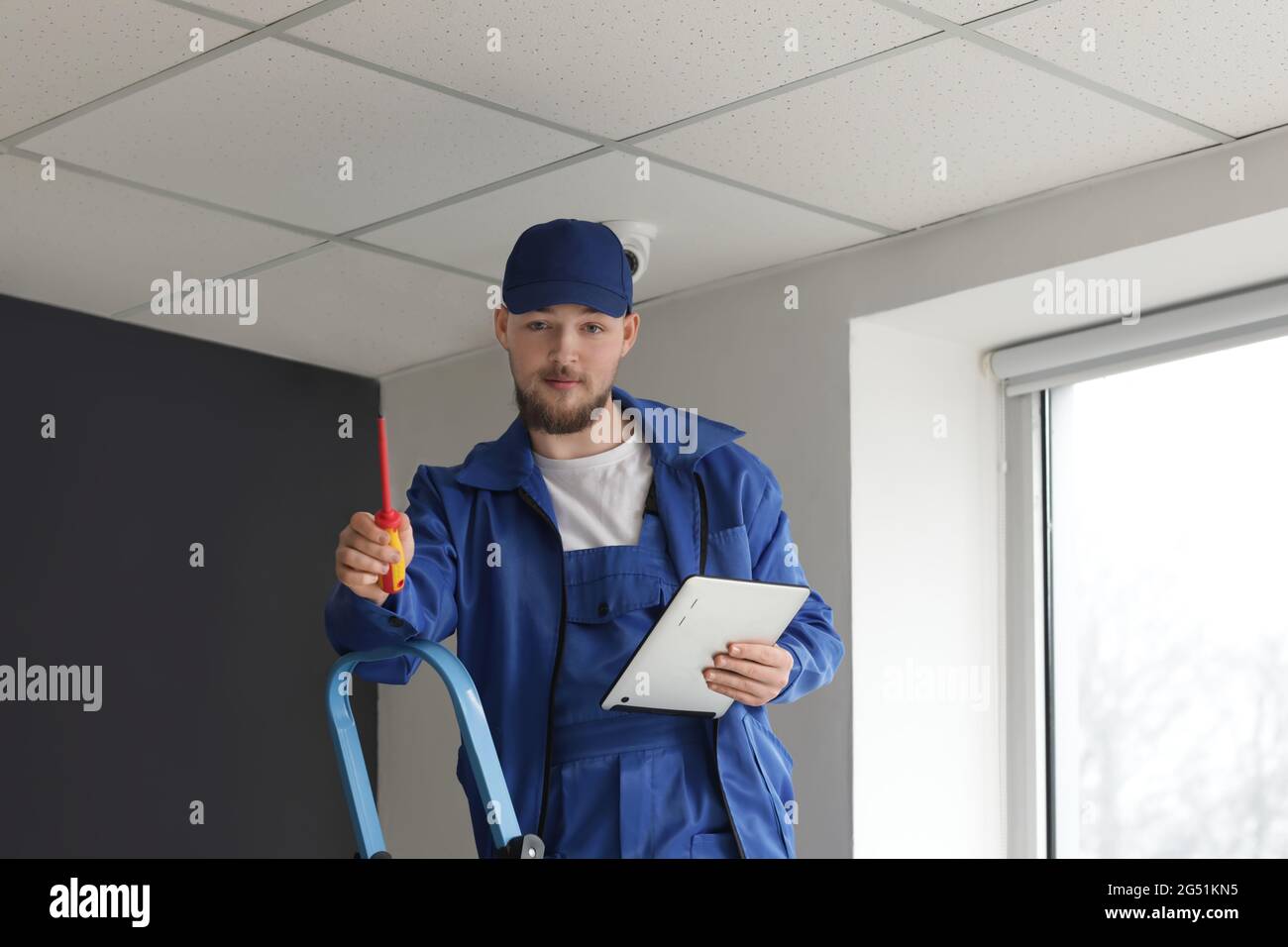 Worker installing alarm system indoors Stock Photo - Alamy