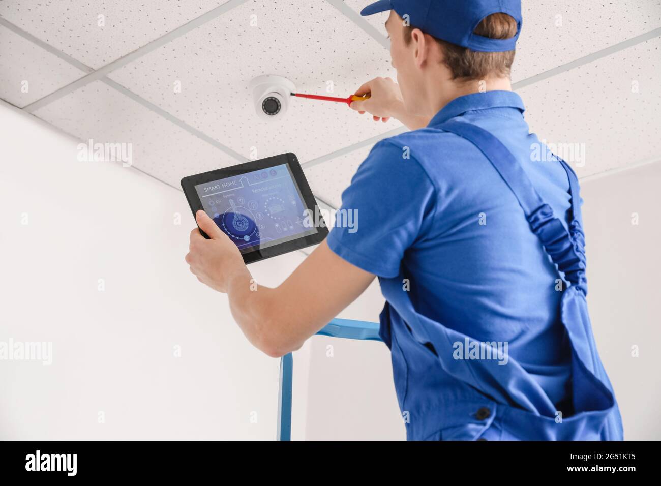 Worker installing alarm system indoors Stock Photo - Alamy