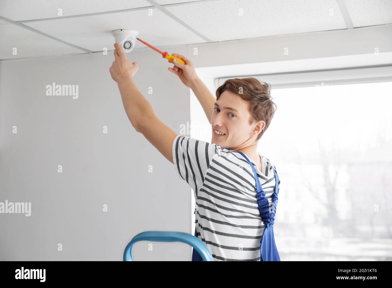 Worker installing alarm system indoors Stock Photo - Alamy
