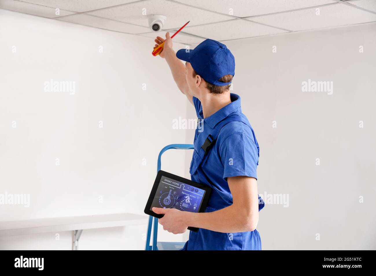Worker installing alarm system indoors Stock Photo - Alamy
