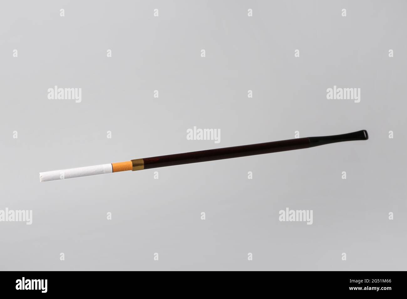 Cigarette with stick on light background Stock Photo - Alamy