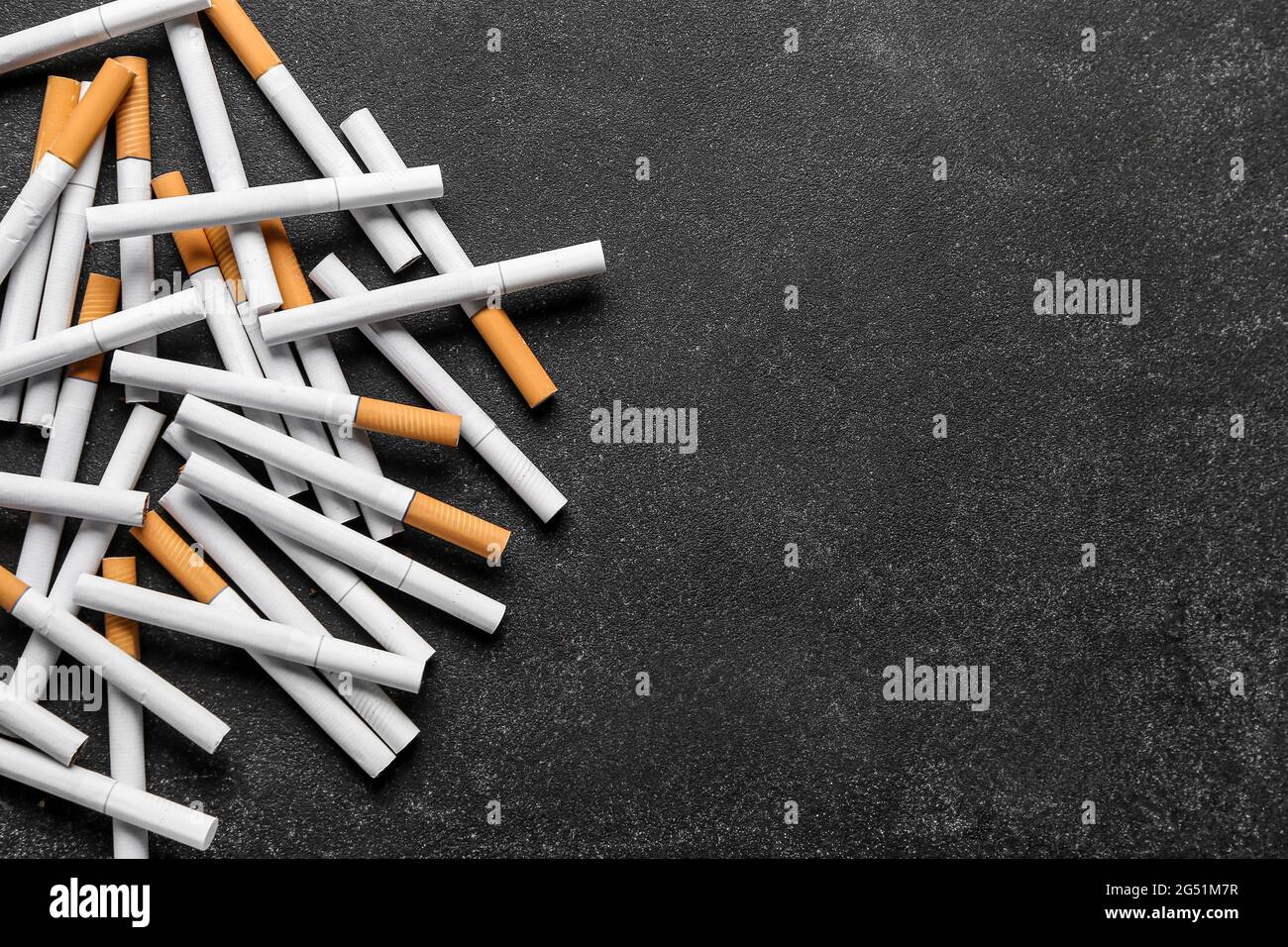 Many cigarettes on dark background Stock Photo - Alamy
