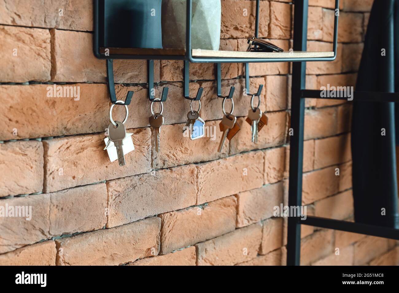 Holder with keys hanging on brick wall Stock Photo - Alamy