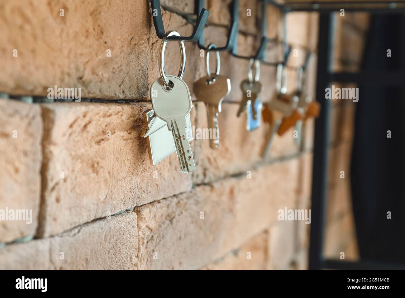 Holder with keys hanging on brick wall Stock Photo - Alamy