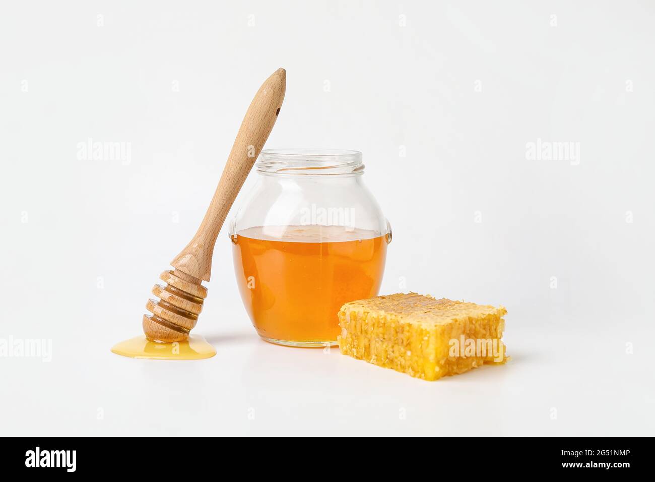 Glass jar with sweet honey, dipper and comb on white background Stock ...