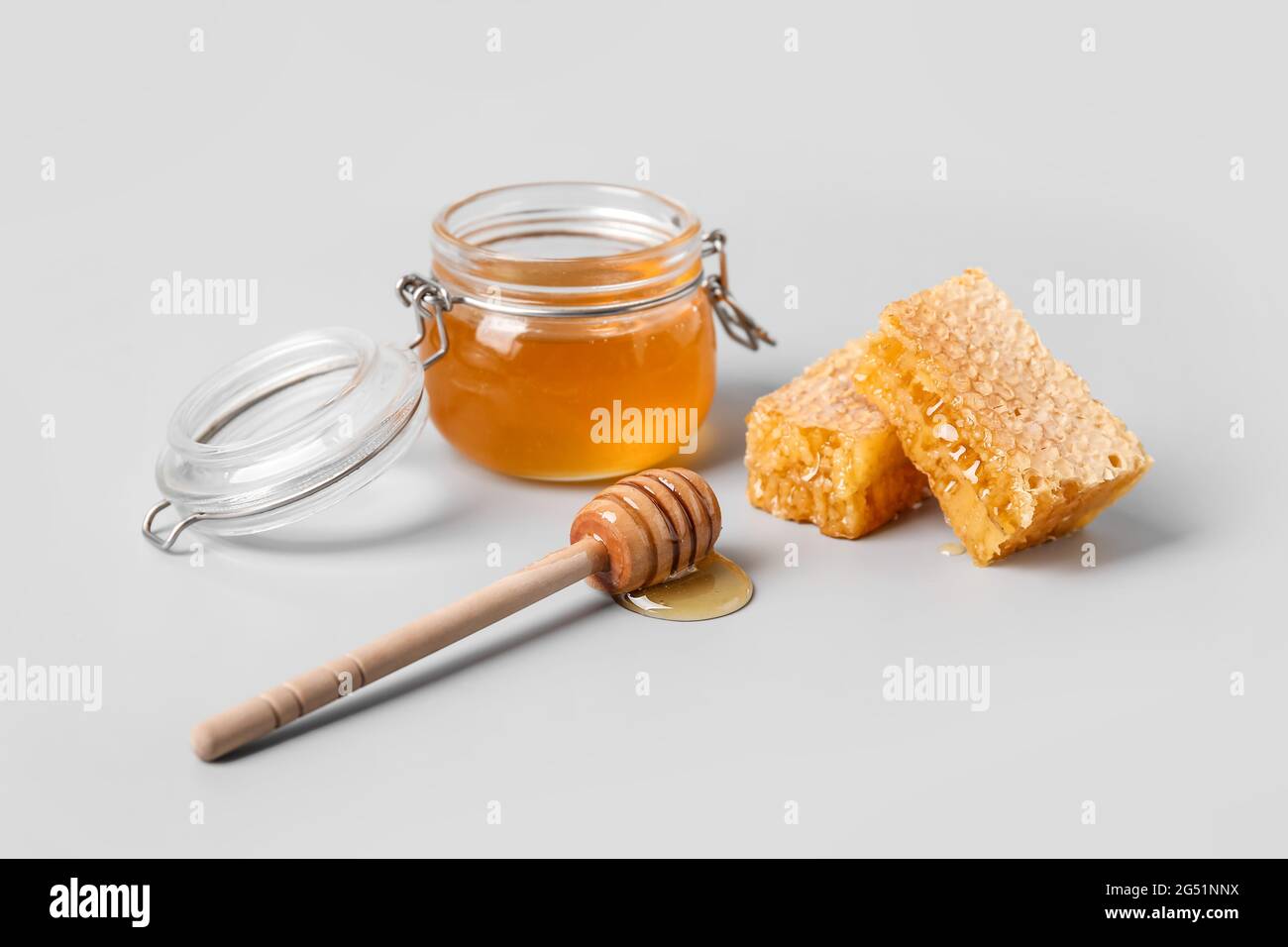 Glass jar with sweet honey, dipper and combs on grey background Stock ...
