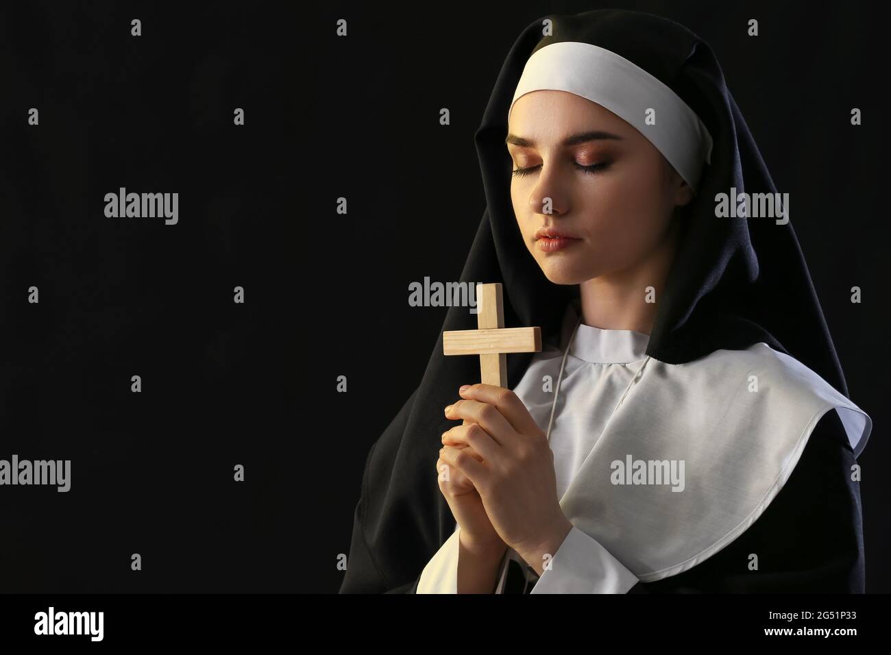 Young praying nun on dark background Stock Photo - Alamy