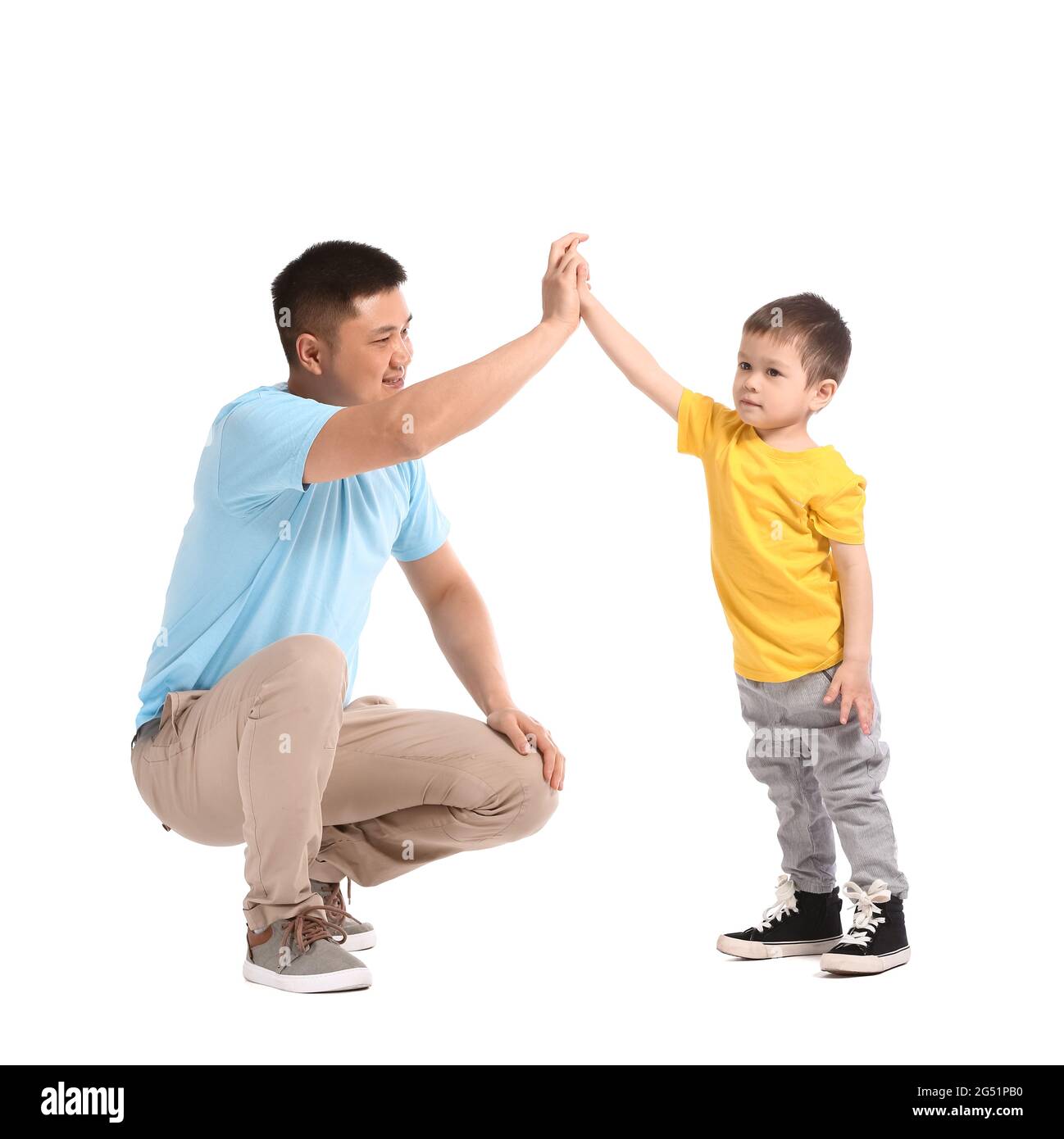 Happy father and his little son giving each other high-five on white ...