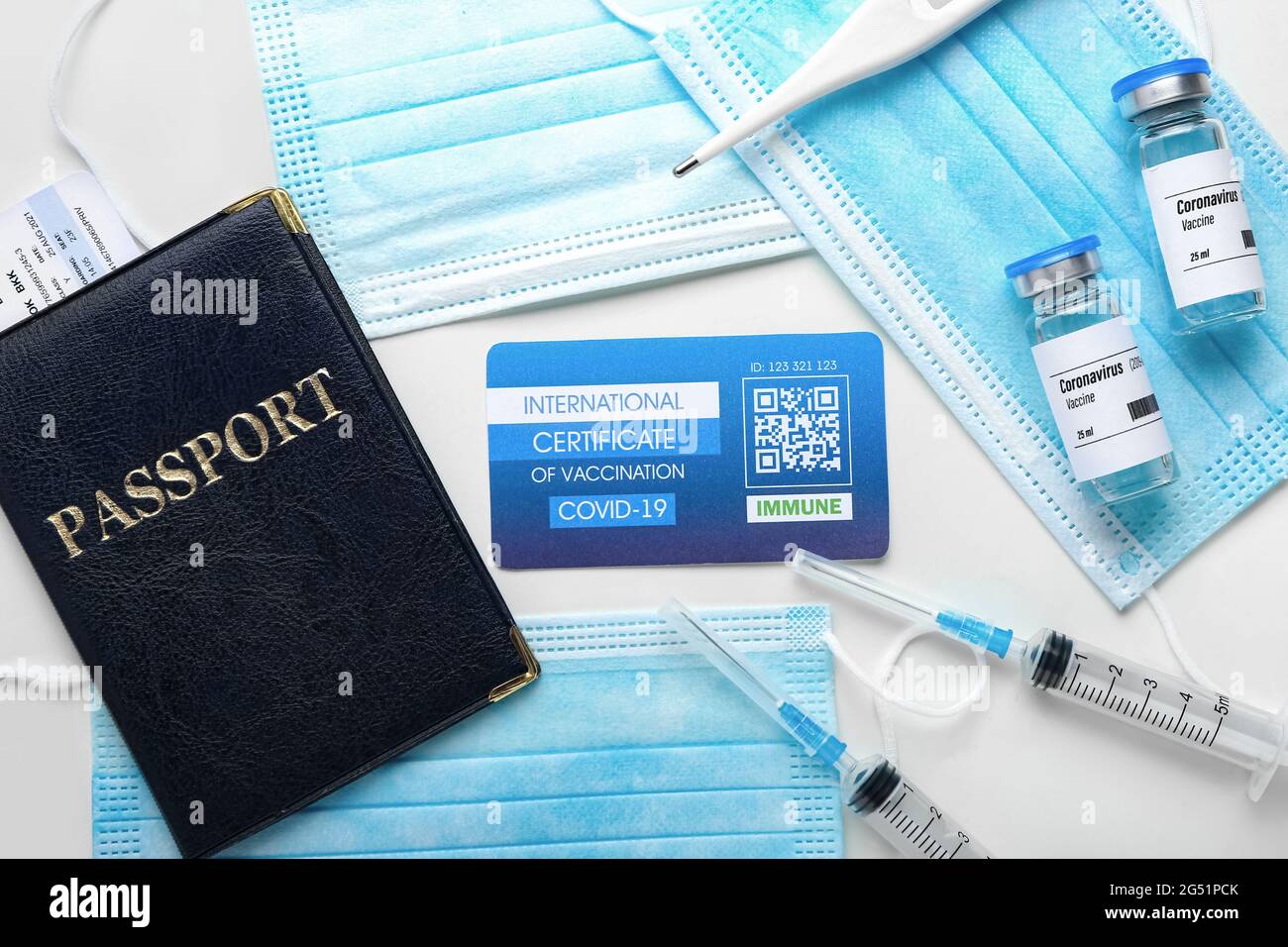Immune card, passport, covid-19 vaccine and medical masks on white ...