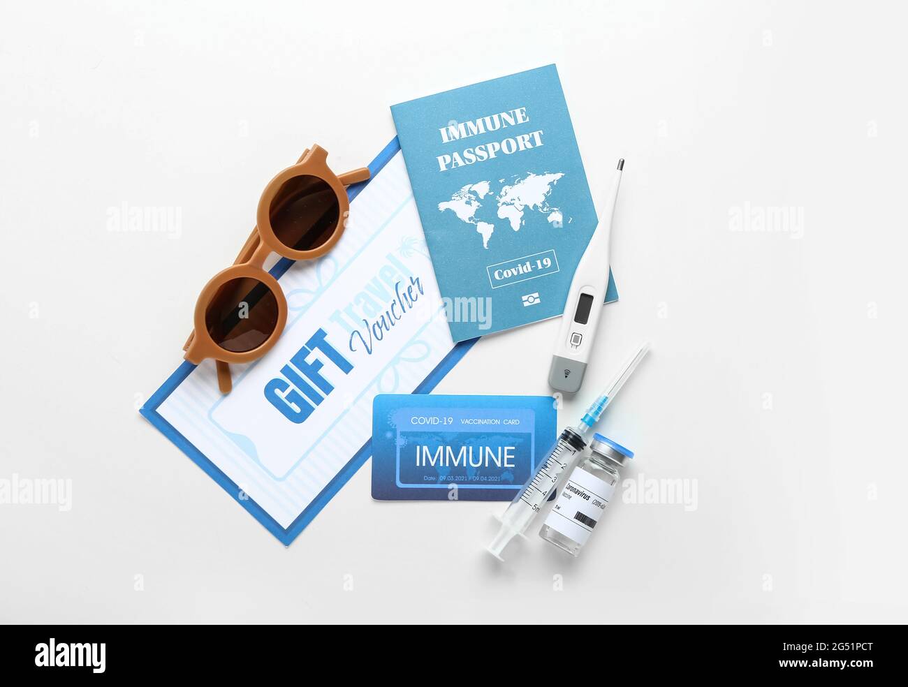 Immune card, passport, covid-19 vaccine and gift voucher on white ...