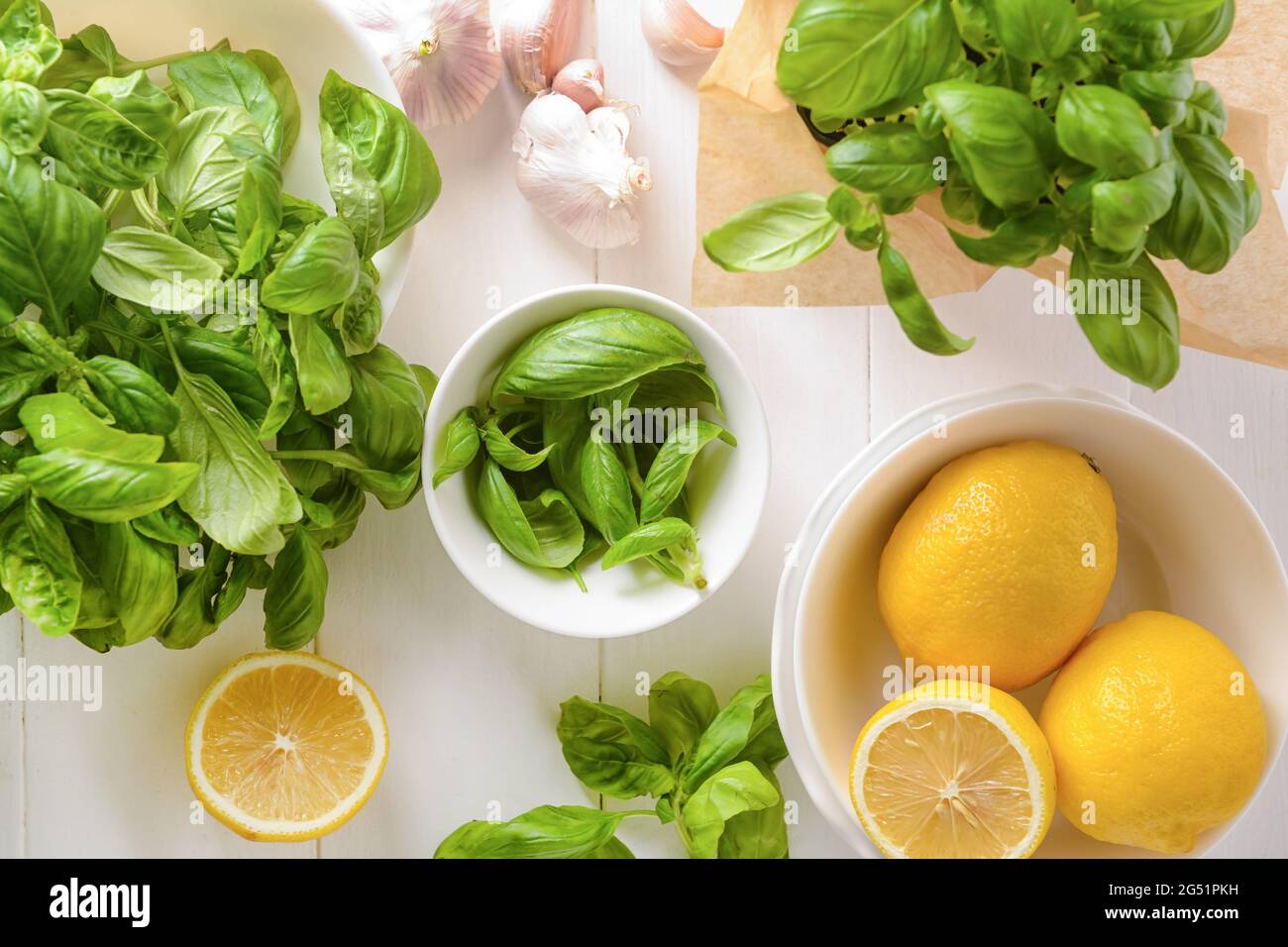 Fresh basil leaves, lemons and garlic on light wooden background Stock ...