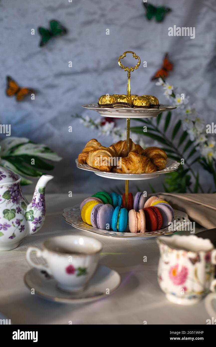 Mystical tea party with colorful baked goods and butterflies Stock ...