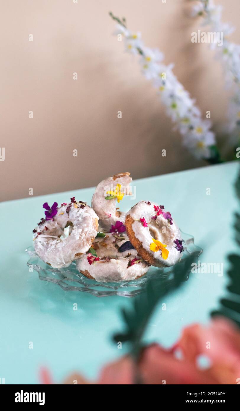 Colorful donut scene with edible flowers Stock Photo - Alamy