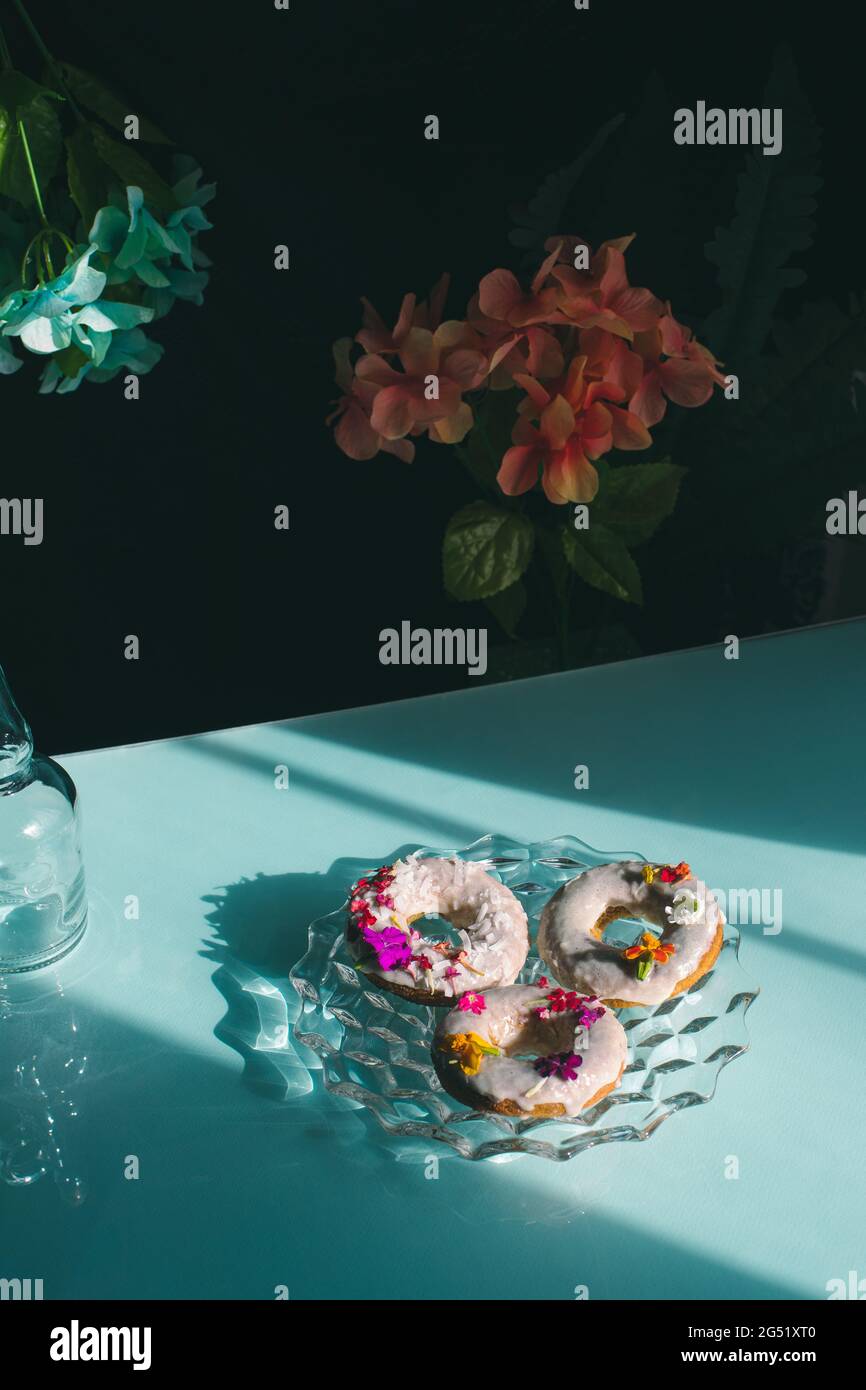 Colorful donut scene with edible flowers Stock Photo - Alamy