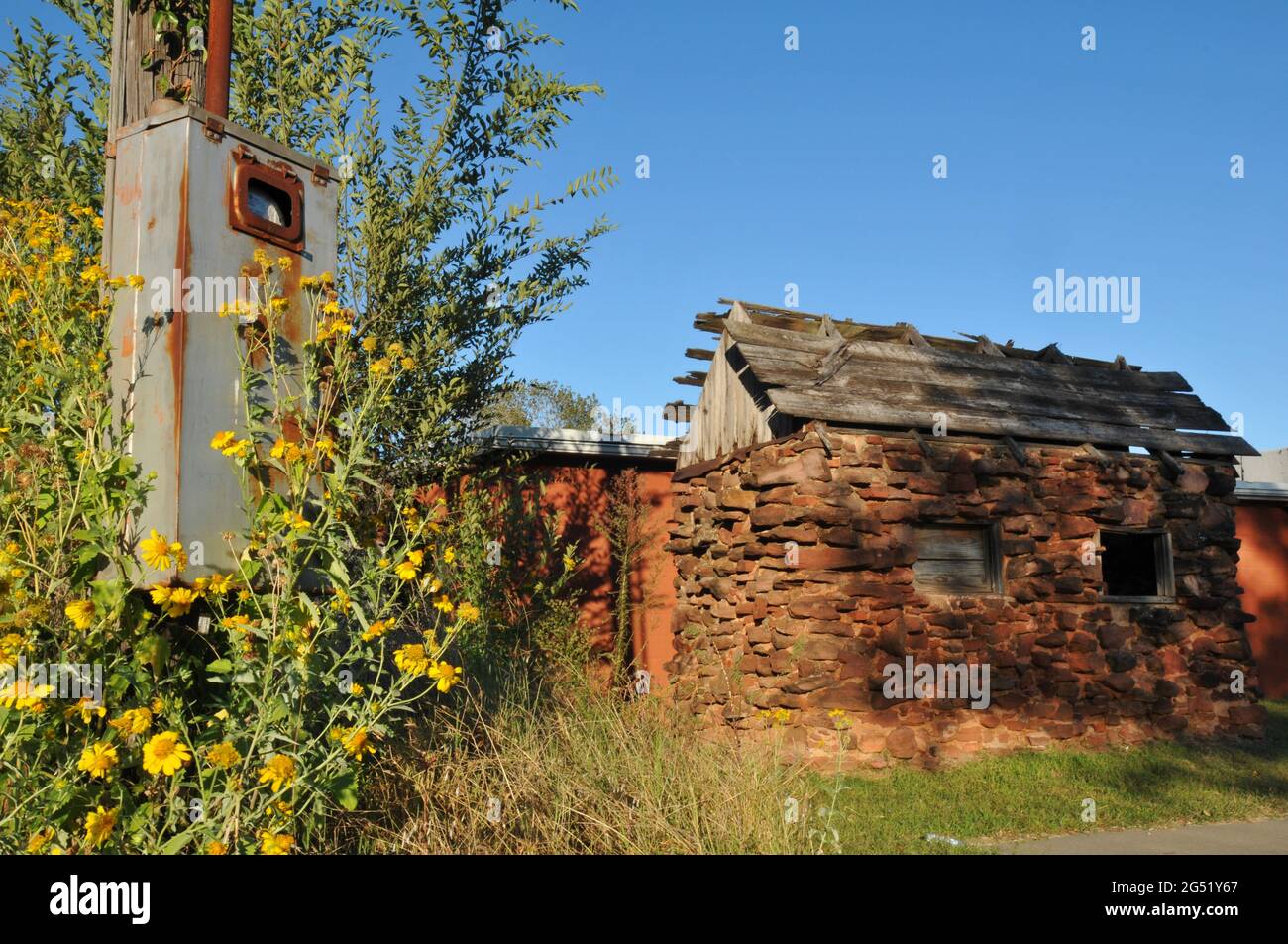 A utility box is mounted on a pole near the historic stone outhouse ...
