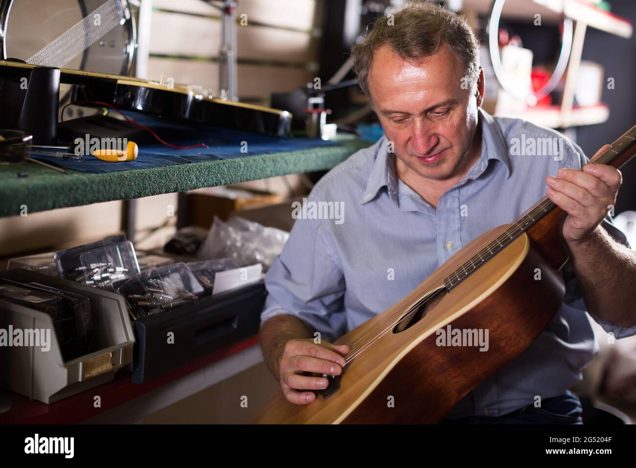 Man is repairing musical instruments Stock Photo - Alamy