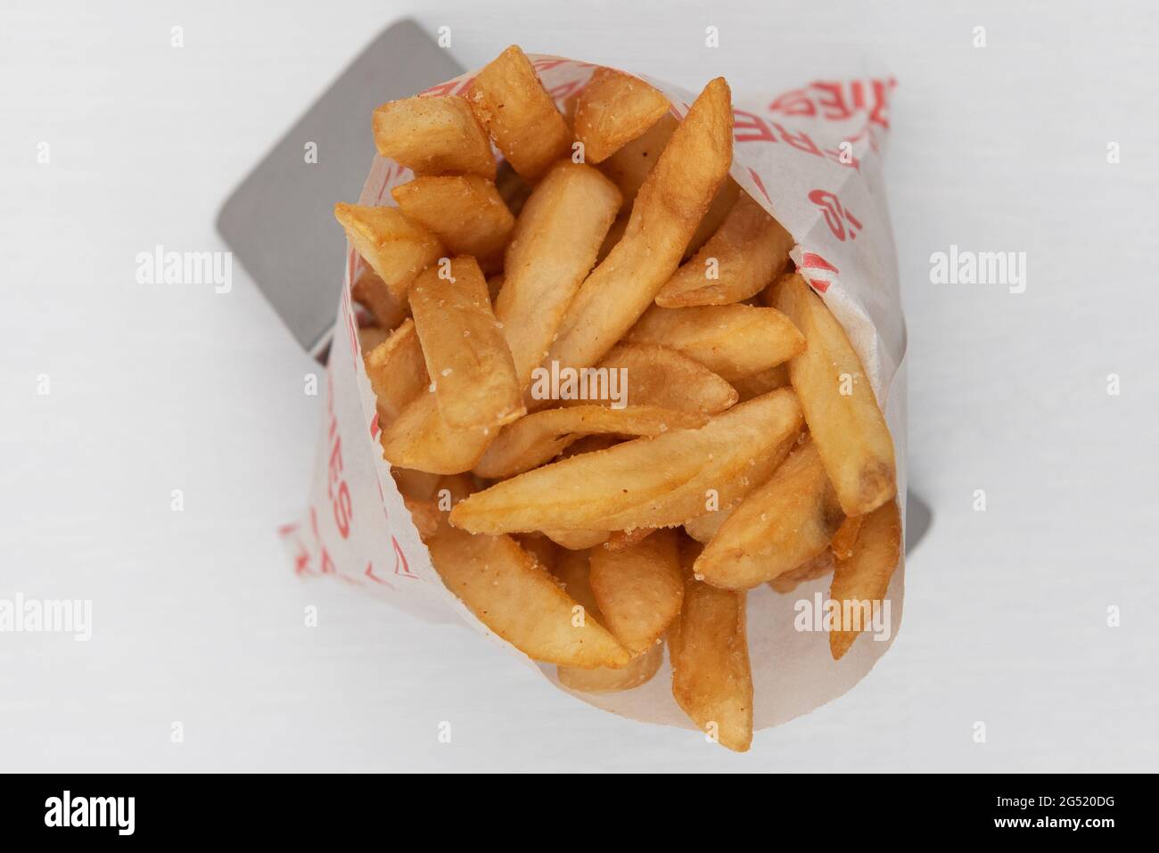Overhead view of side order of a bag of crispy french fries served in a ...