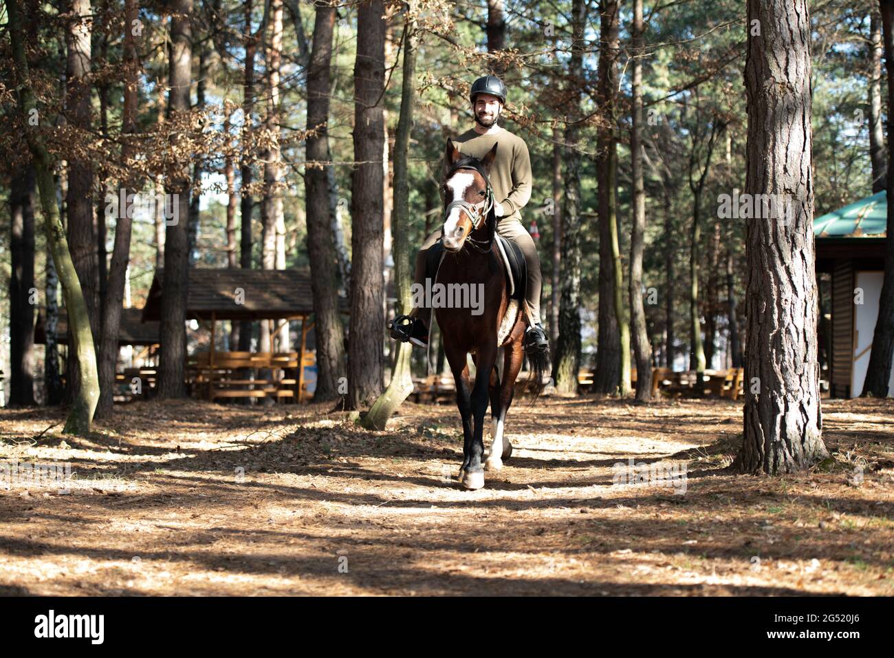 Young Man Jockey Riding Brown Horse Strolling Across Field Stock Photo - Alamy