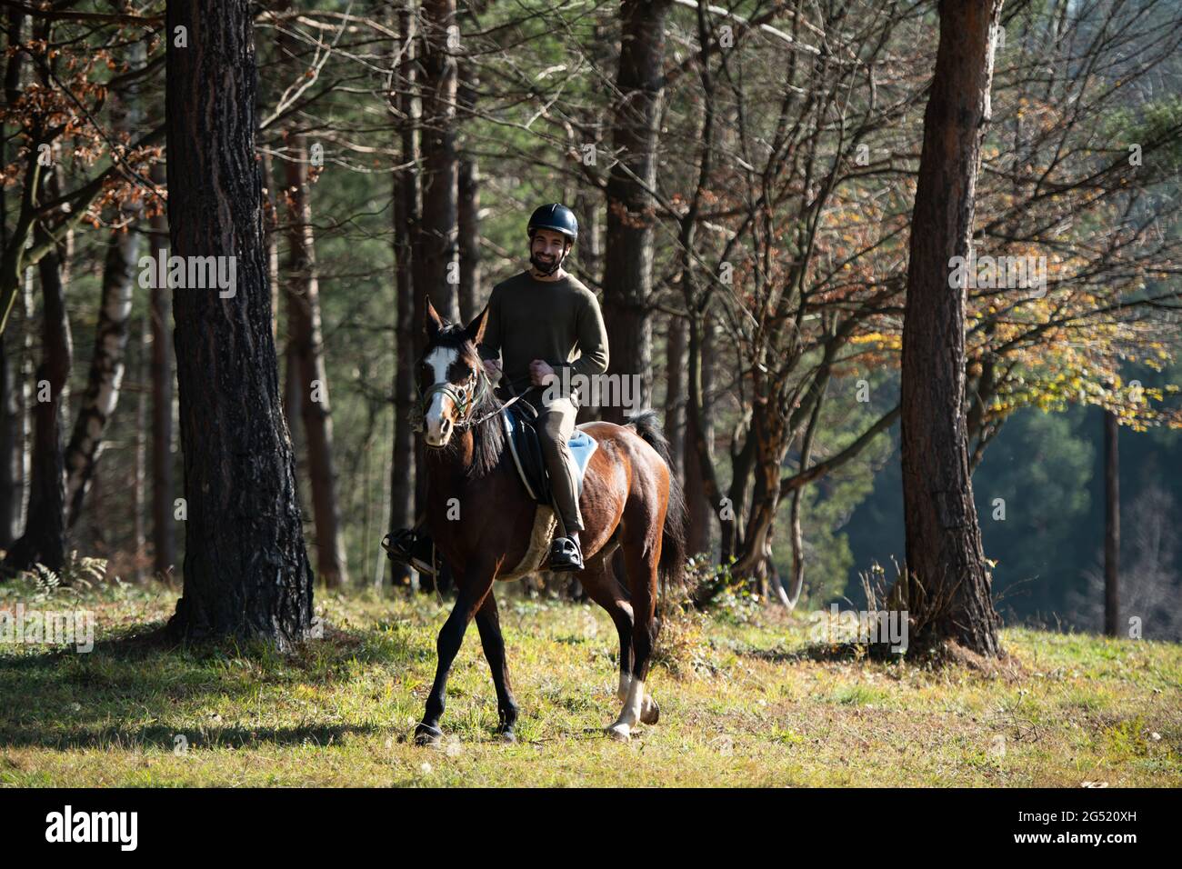 Young Man Jockey Riding Brown Horse Strolling Across Field Stock Photo - Alamy