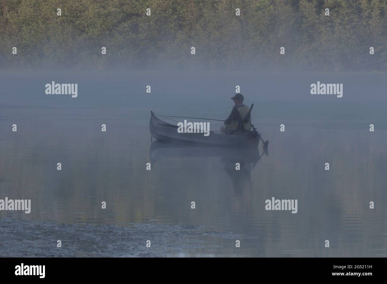 The fisherman with a small boat in a foggy morning Stock Photo - Alamy