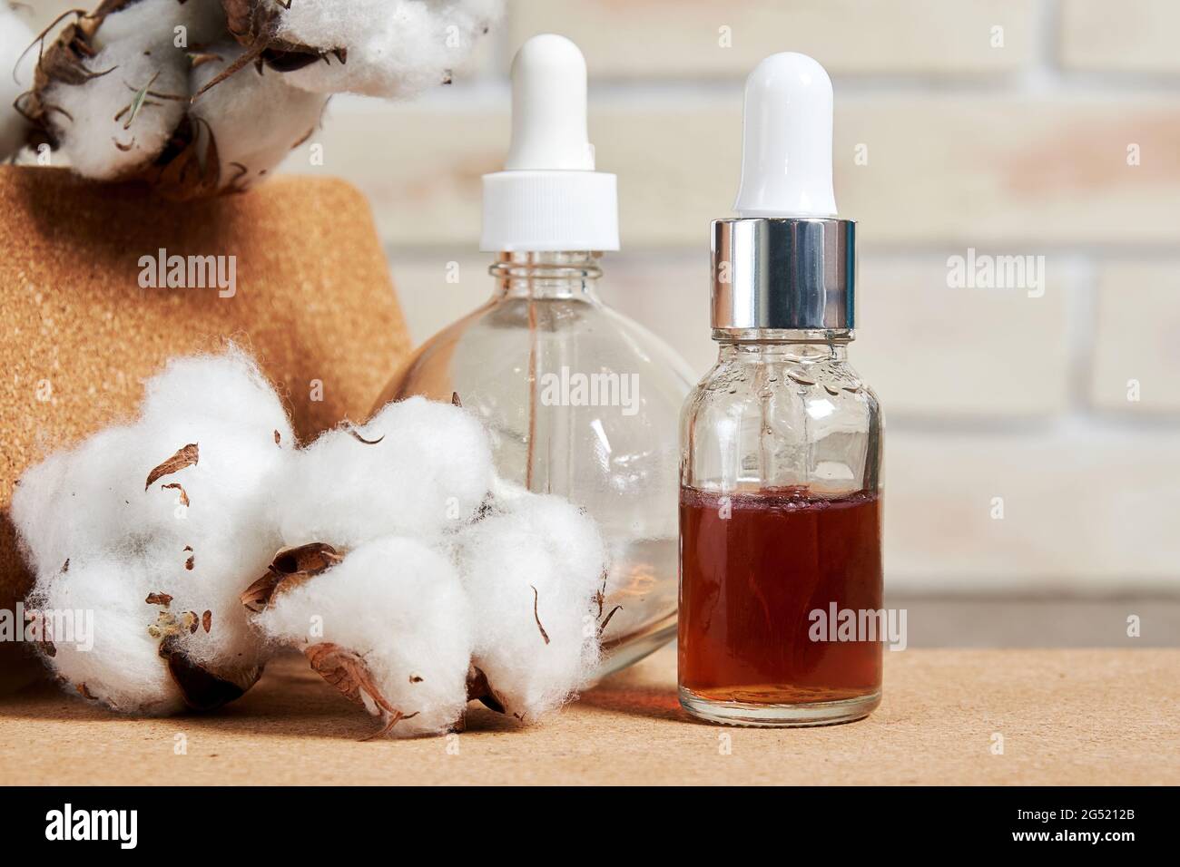Brown flask with facial cosmetics tonic. Cotton flowers on the makeup ...