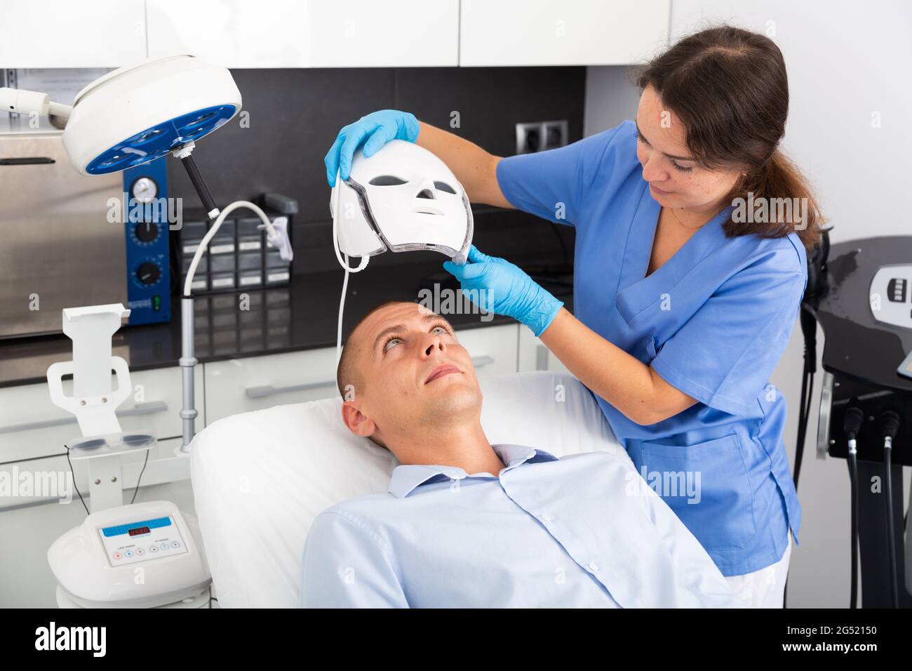 Man receiving facial light therapy in aesthetic medicine office Stock ...