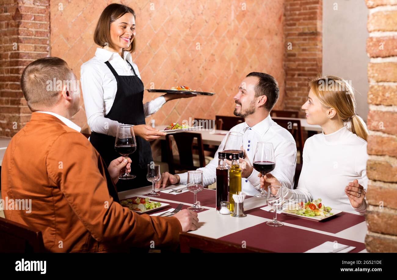 Female waiter carrying order for visitors Stock Photo - Alamy