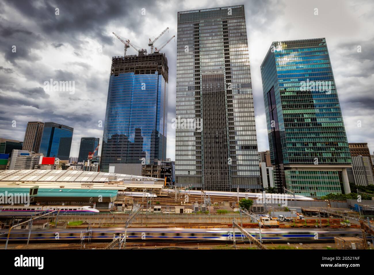 A building still under construction in Tokyo, Japan as trains depart ...