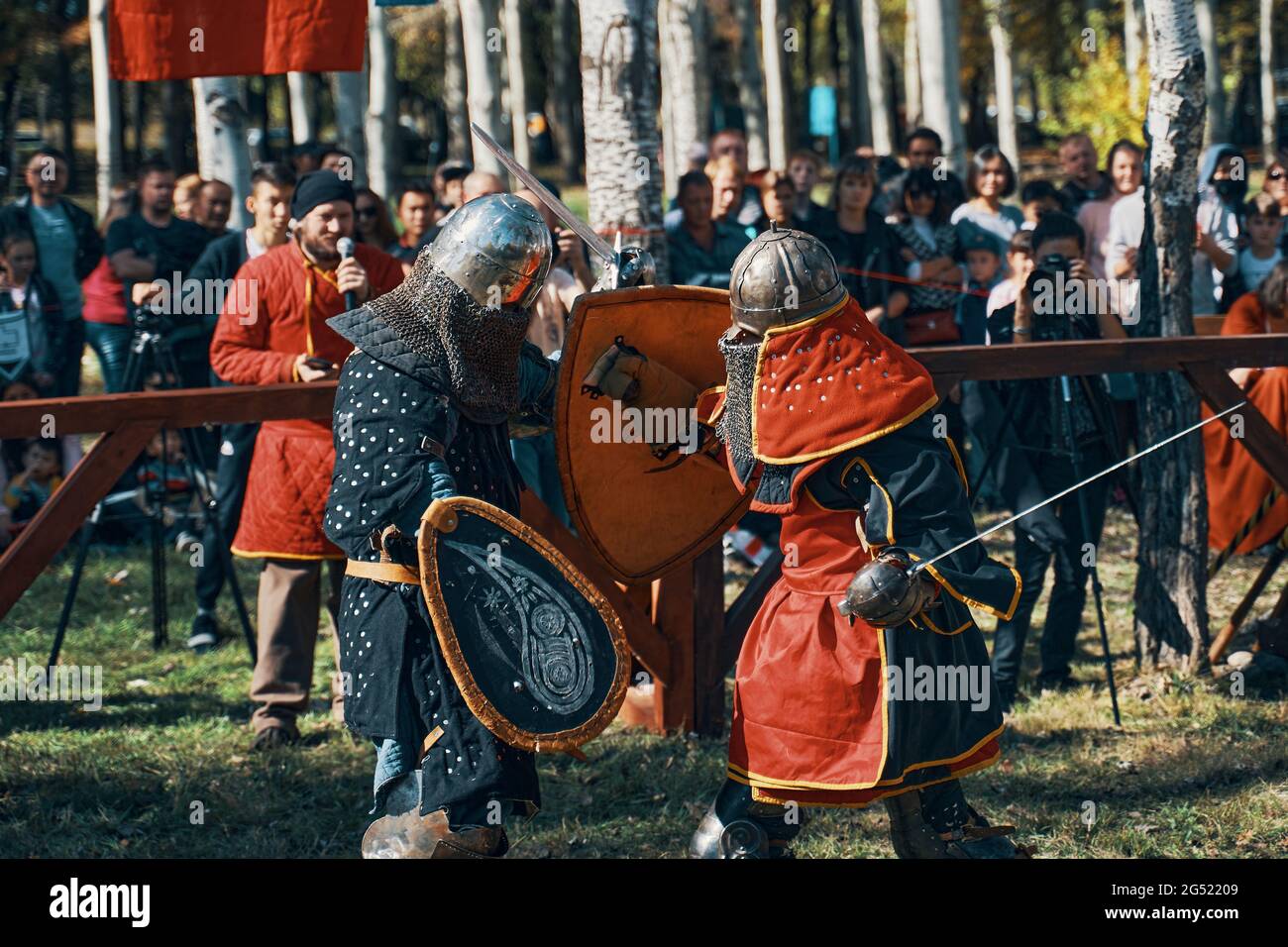 An epic sword battle. Two knights in armor and helmets, with shields in ...