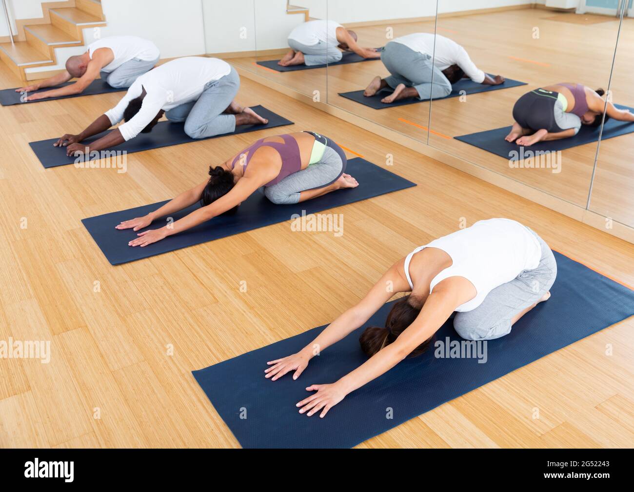 Group of sporty people practicing yoga positions during training Stock ...