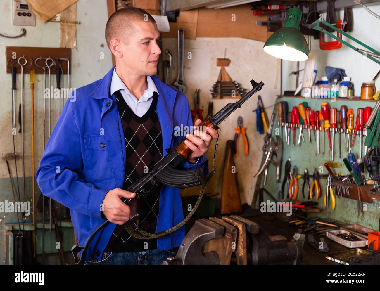 Gunsmith checks Kalashnikov assault rifle in weapons workshop Stock ...