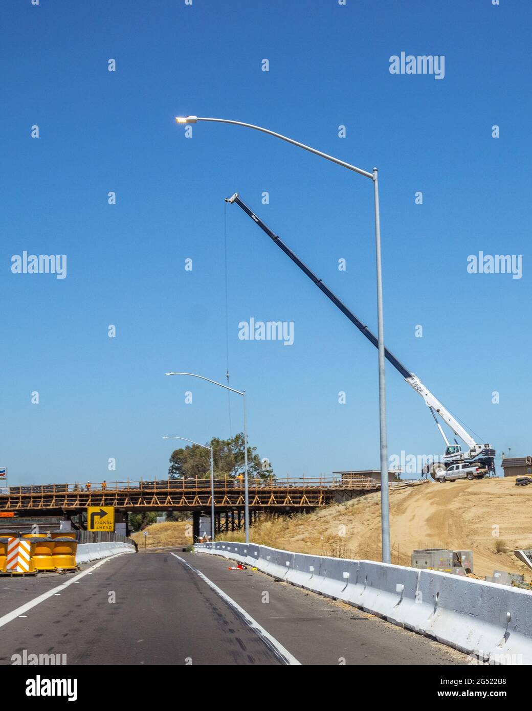 A very tall crane works on the new bridge at the intersection of ...