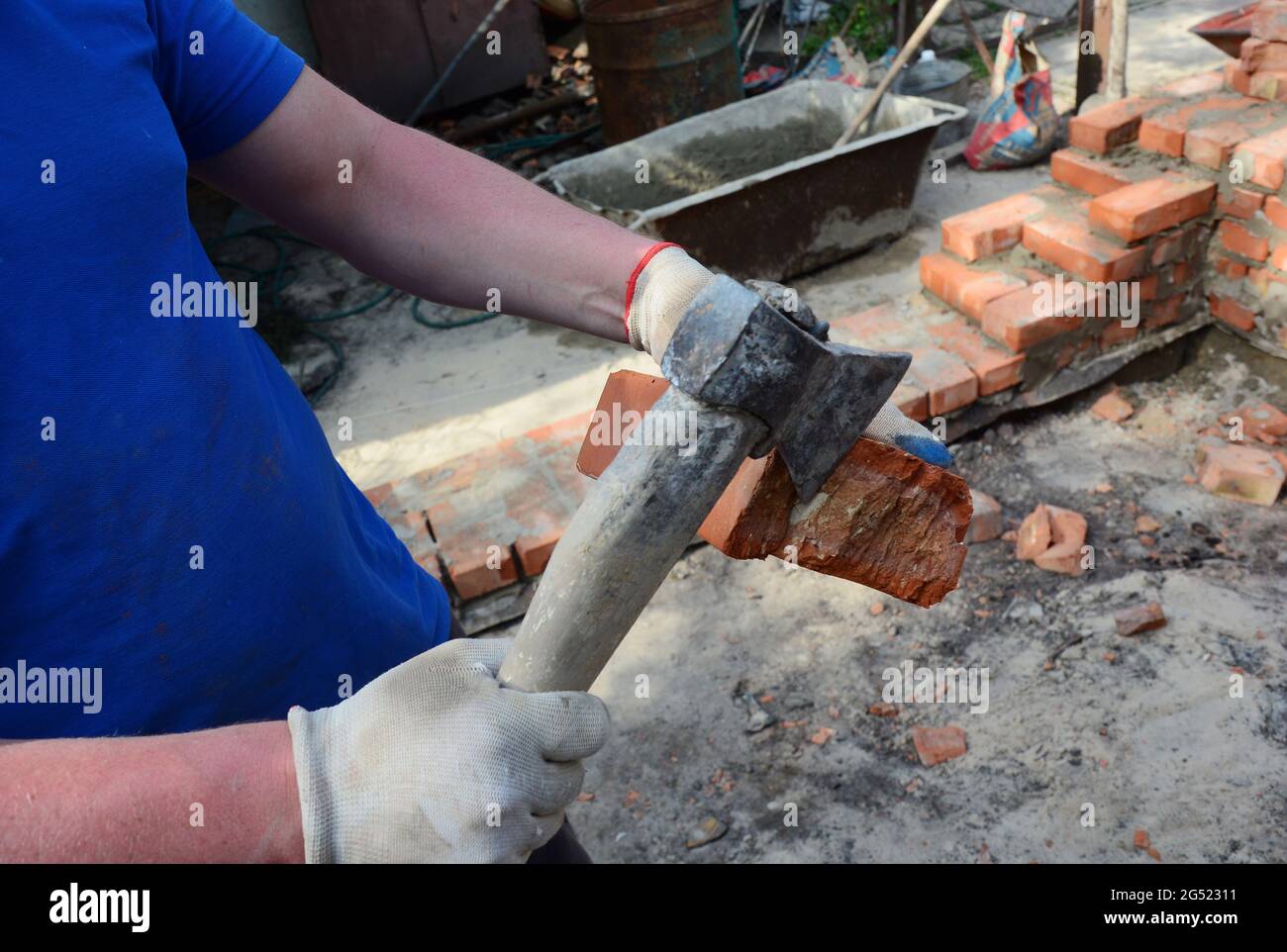 Masonry. How to hand cut a brick. A bricklayer is cutting a brick using ...