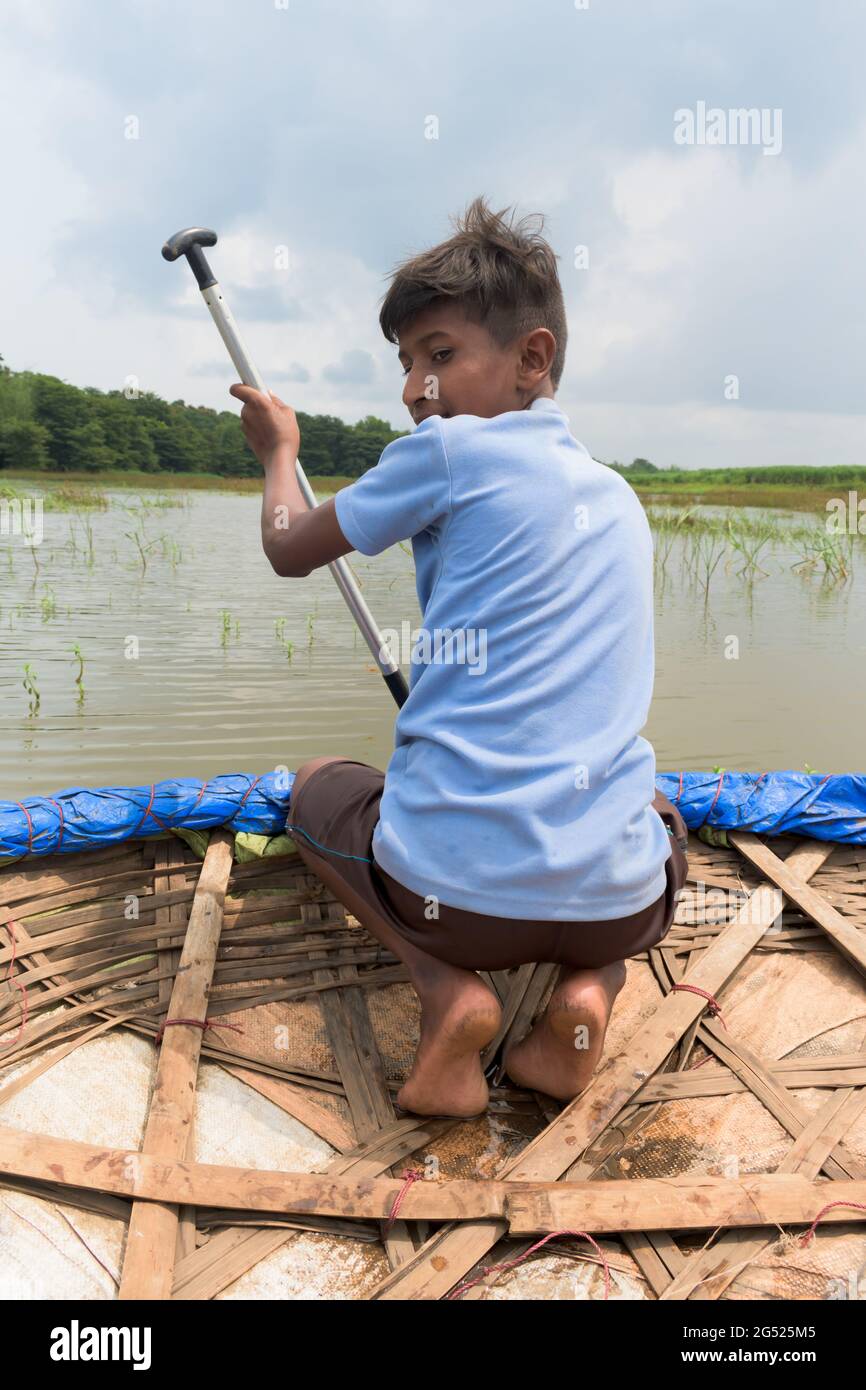 Young teenage boy from rural India rowing coracle, a traditional bamboo ...