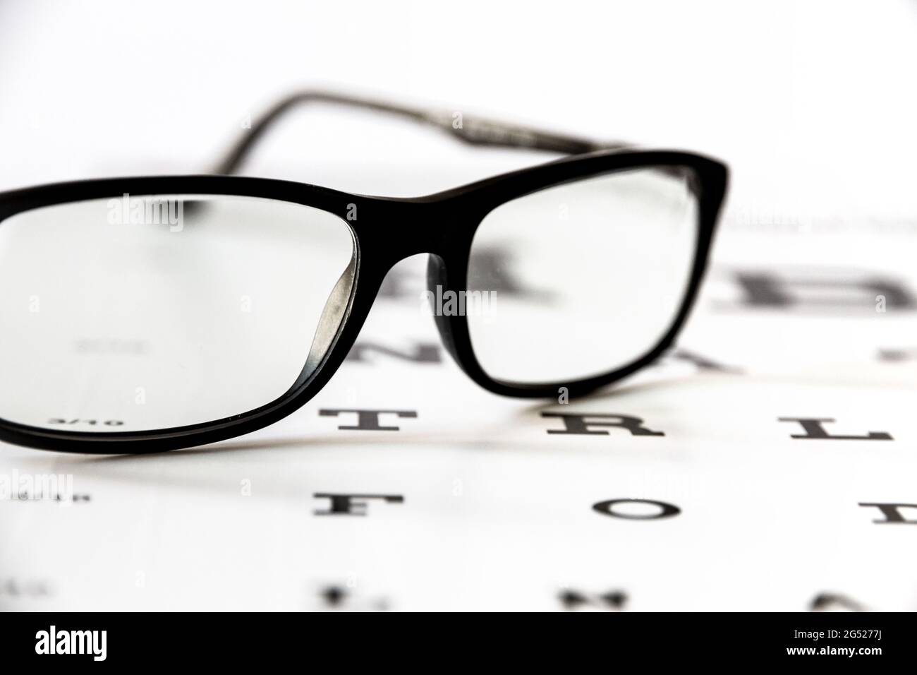 Glasses on eye chart. Optical device background Stock Photo - Alamy