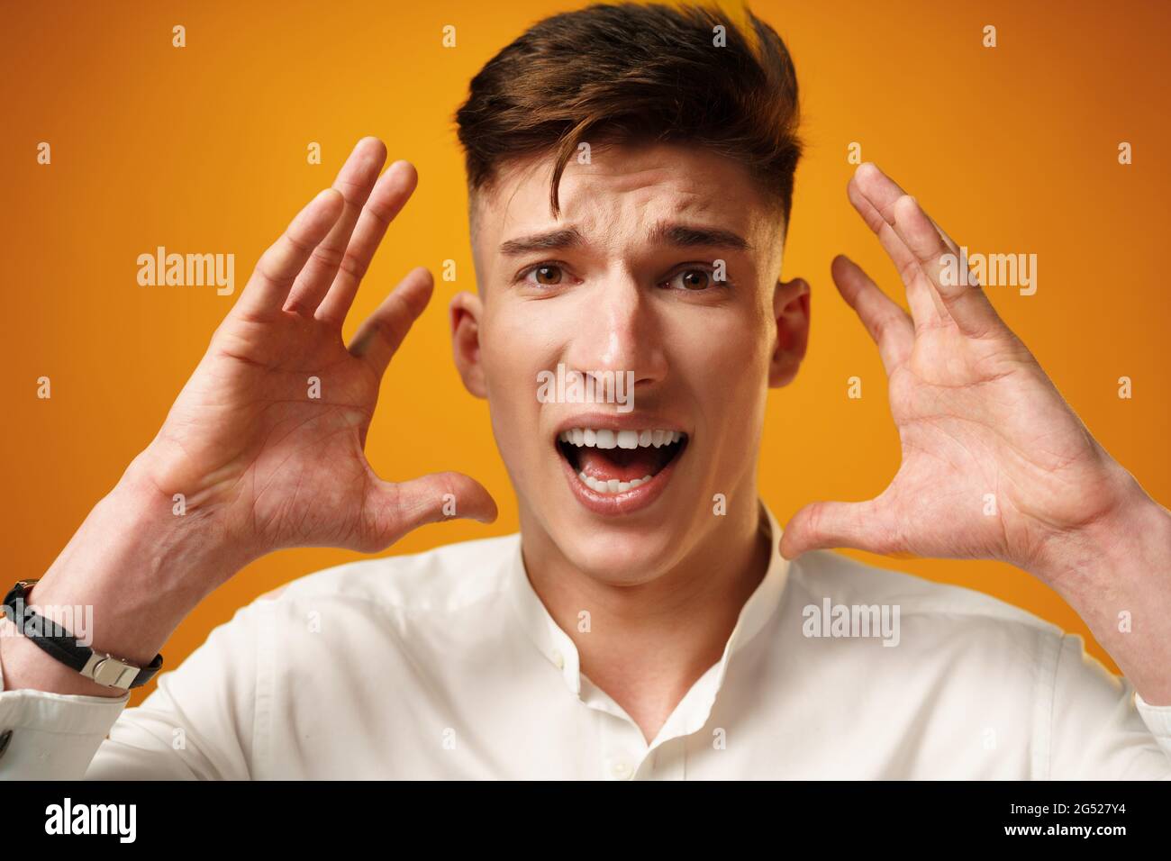 Stressed shouting young man holding hands near his head Stock Photo - Alamy