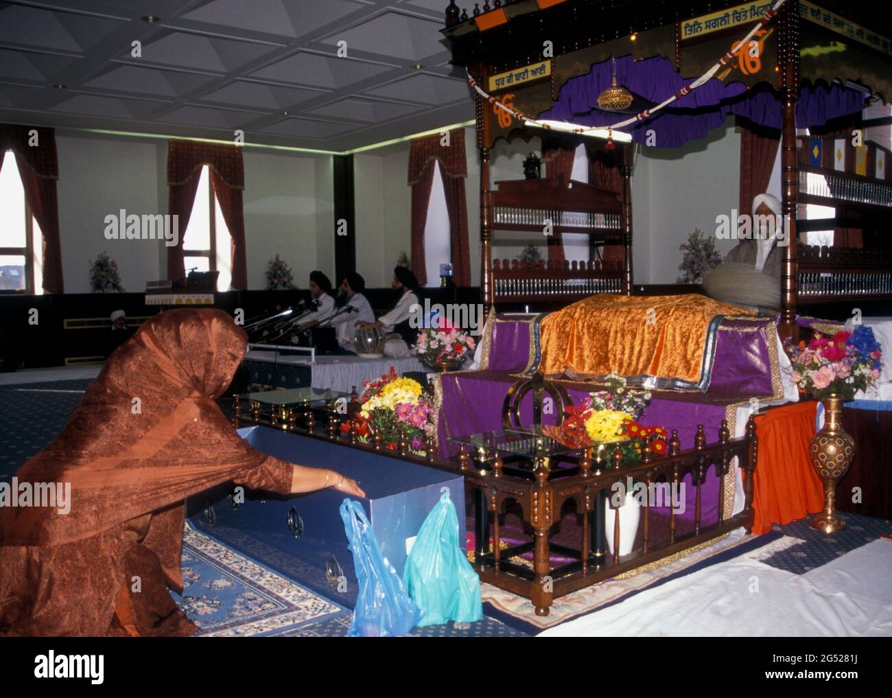 Typical scene during a service in the gurdwara. Rajis, background, is ...