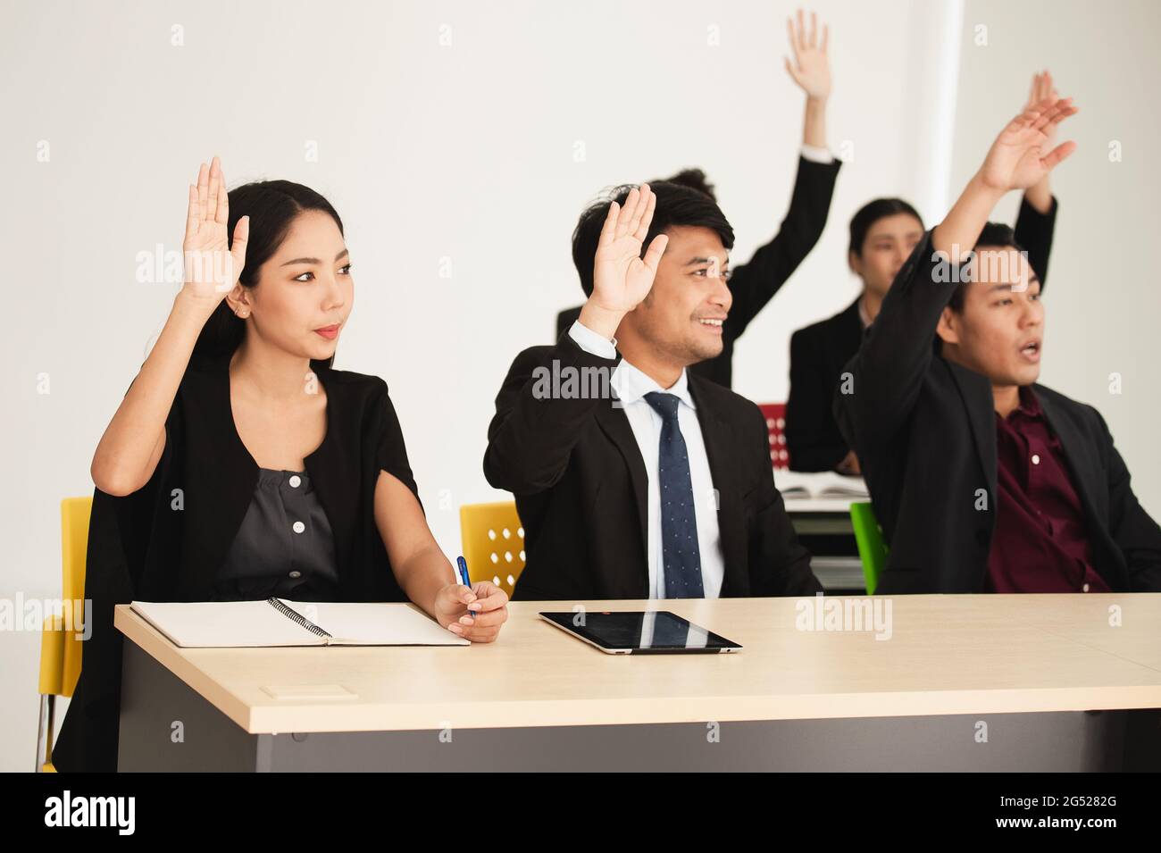 People raising their hands to ask questions at the meeting Stock Photo ...