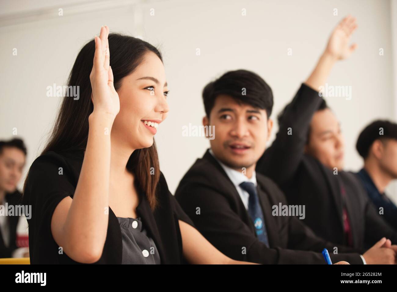 People raising their hands to ask questions at the meeting Stock Photo ...