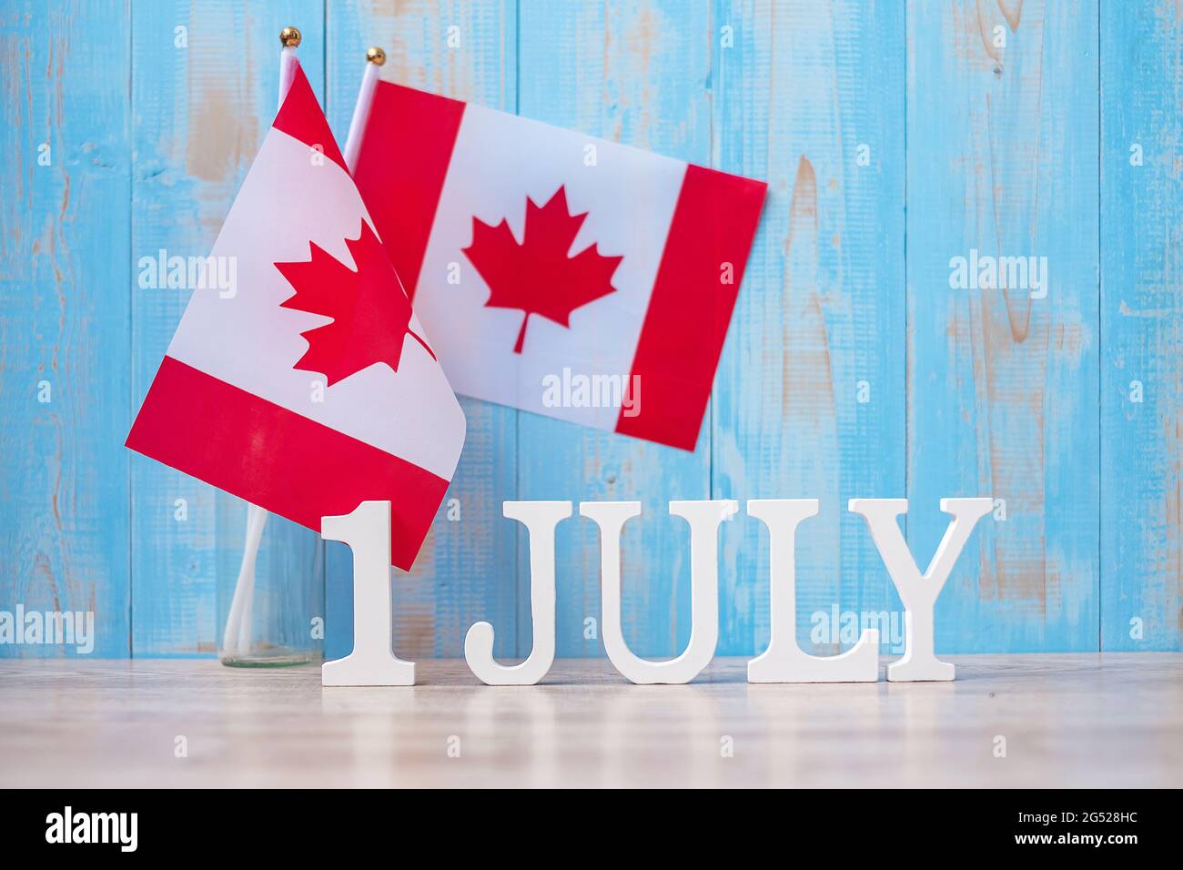 Wooden calendar of July 1st with miniature Canada flags. Canada Day and ...