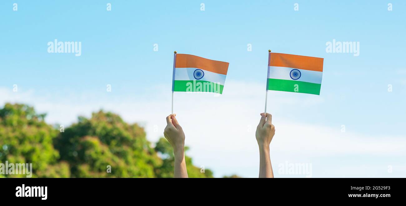hand holding India flag on blue sky background. Holiday of India ...