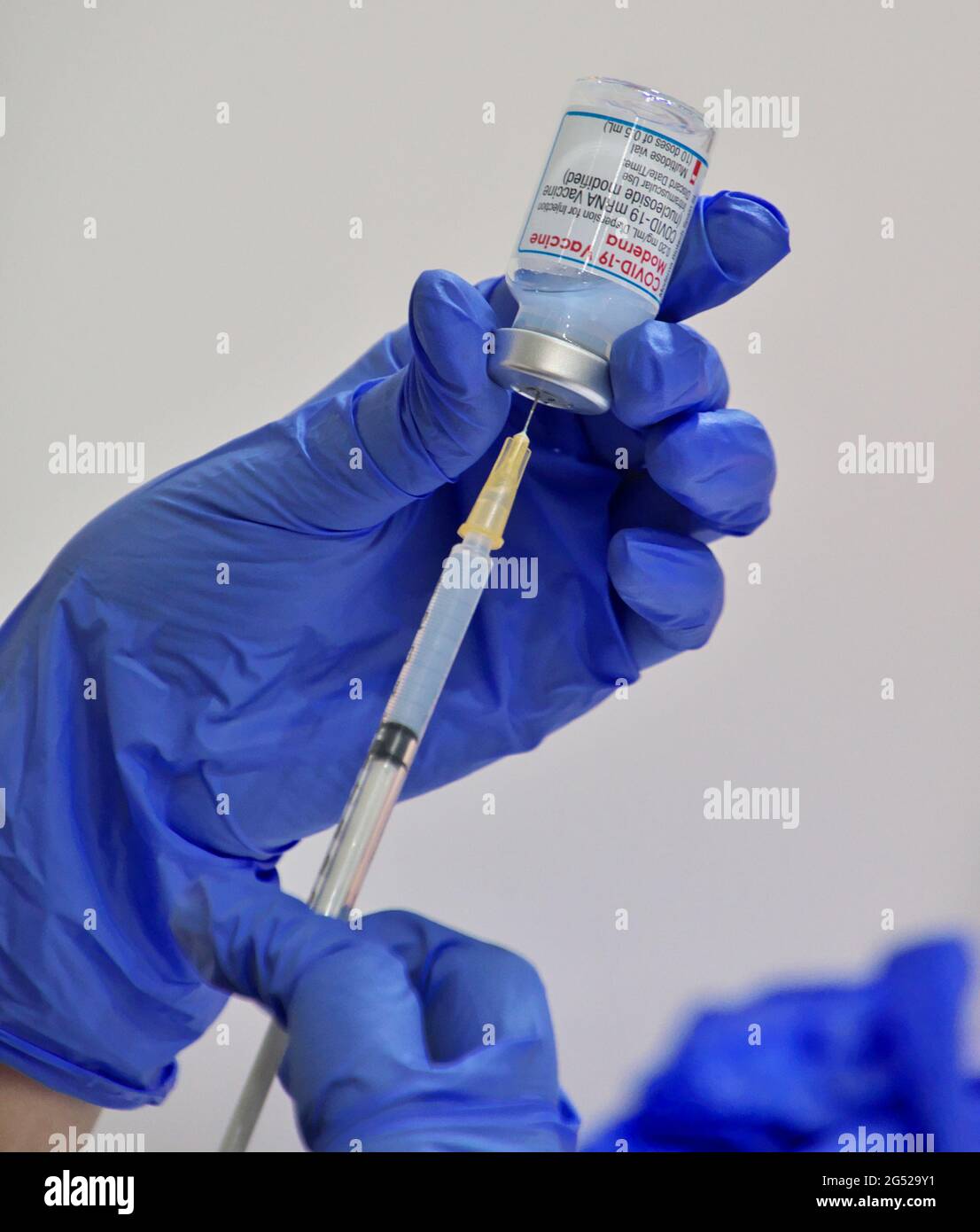 A medical worker fills a syringe with a Moderna COVID-19 vaccine at ...