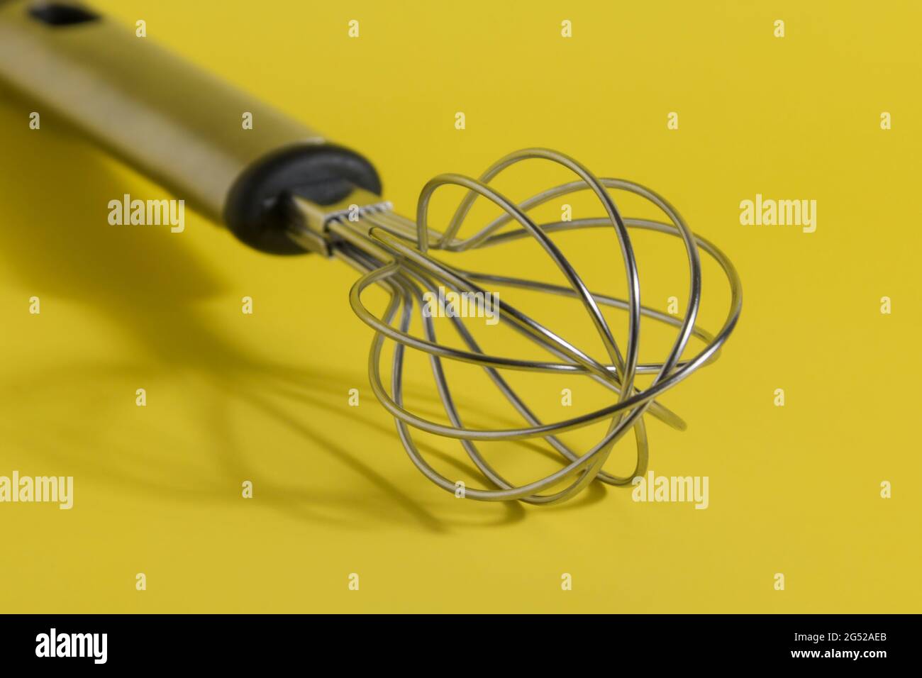 whisk on yellow background. Kitchenware Stock Photo - Alamy