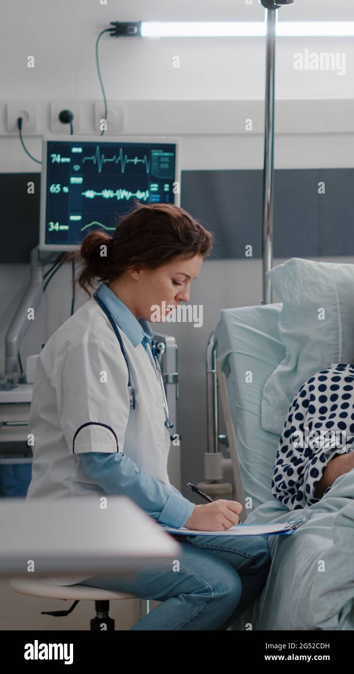 Black nurse checking patient vitals monitoring heart rate injecting ...